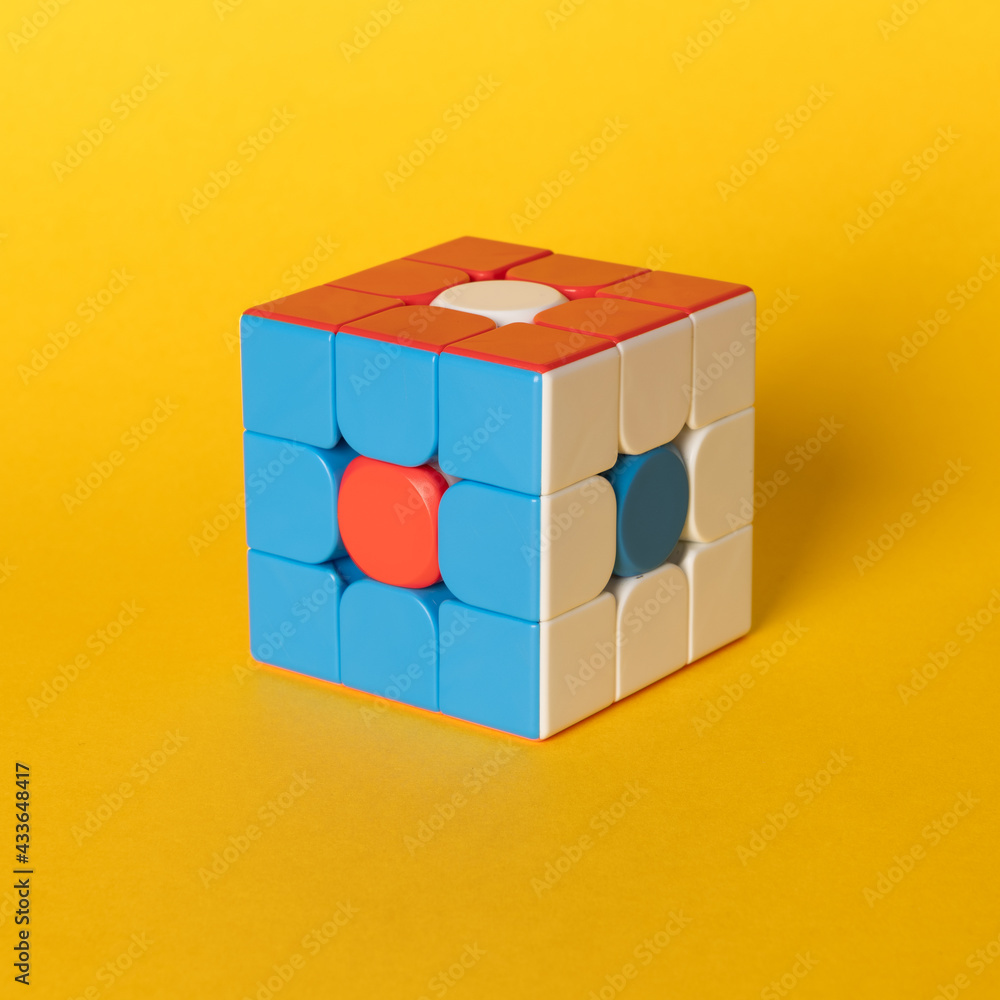 Colourful Rubik cube placed on a coloured background. There is three sides of the cube visible ...