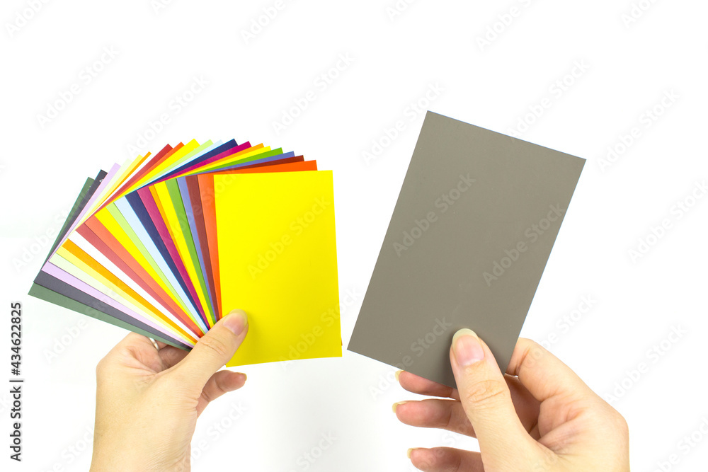 Hands holds acolor palette of paints on a white background. Color card ...