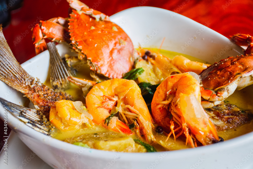 Delicioso caldo de mariscos con cangrejo, pescado, plátano, camarones ...