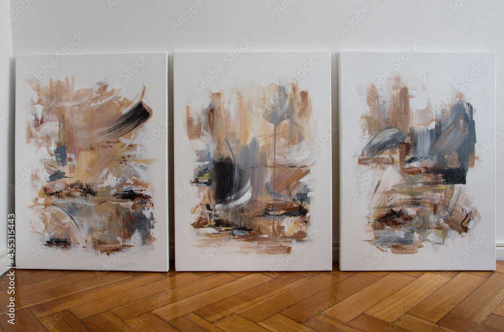 Art collection. Three contemporary abstract paintings on the wooden ...