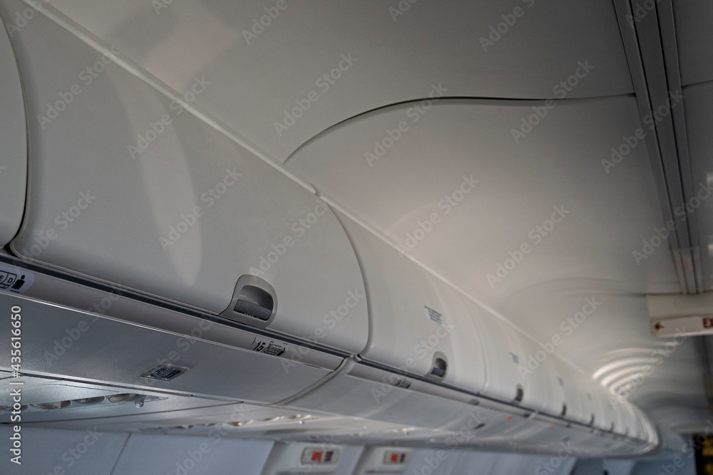 Closed overhead bins and seat numbering in an empty airplane cabin ...