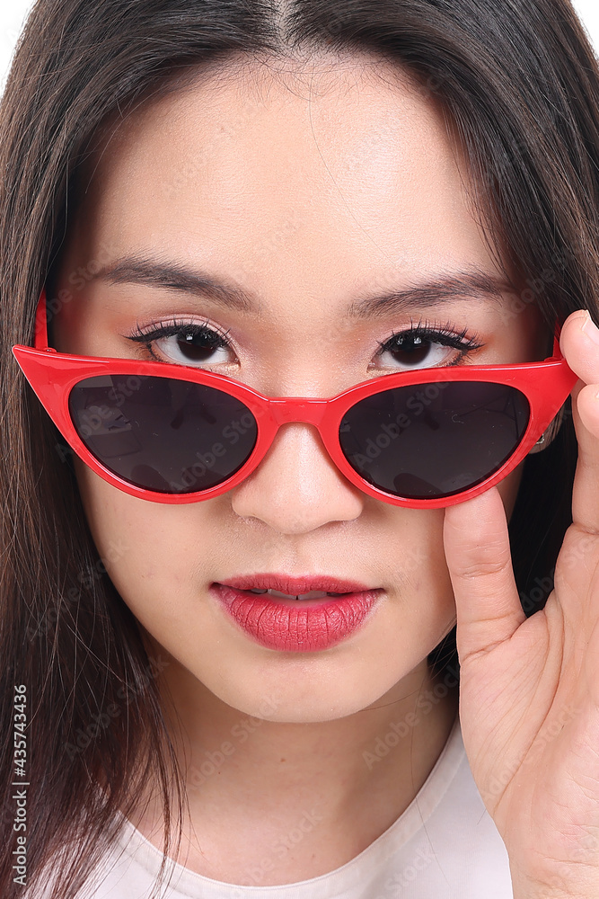Beautiful young south east Asian woman peaking over wearing red frame ...