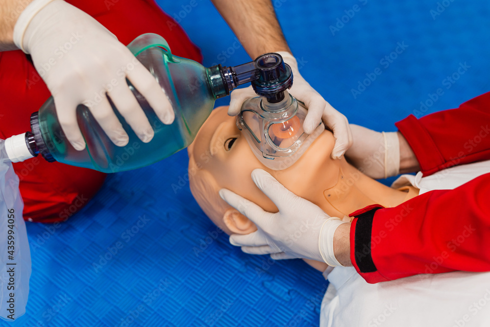 First Aid Training - CPR training medical procedure, Using an oxygen mask on a CPR dummy. Stock ...