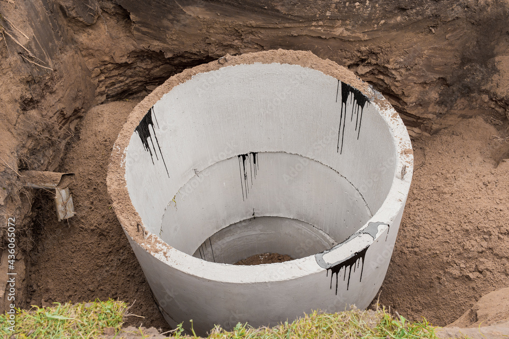 Concrete sewer rings in the ground. Construction or repair of sewerage ...