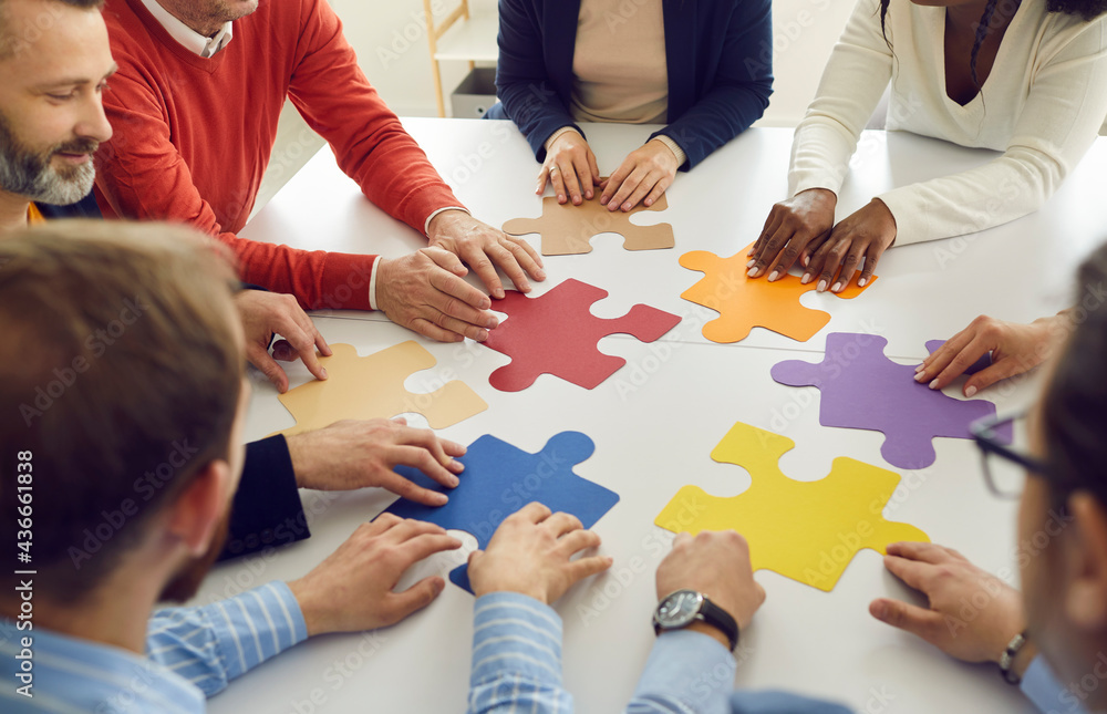 Collaboration concept. Diverse multiethnic people group team assembling jigsaw putting puzzle ...
