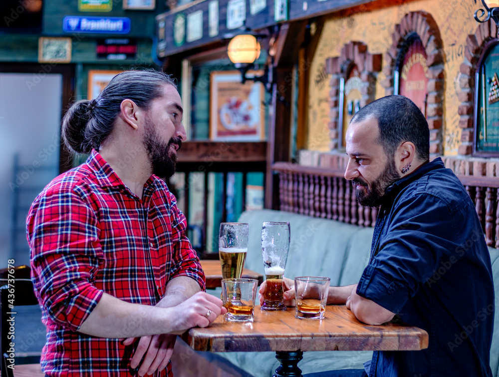 Two male friends drinking whiskey and beer together at the pub. They ...