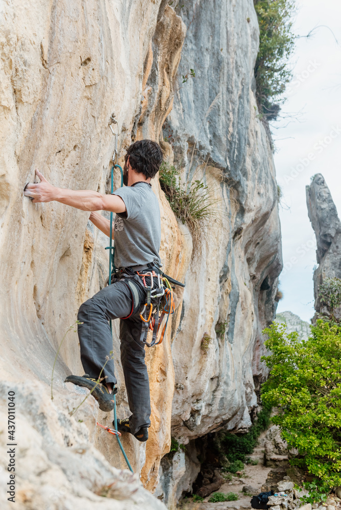 Vertical photograph of young man practicing mountain climbing. boy ...