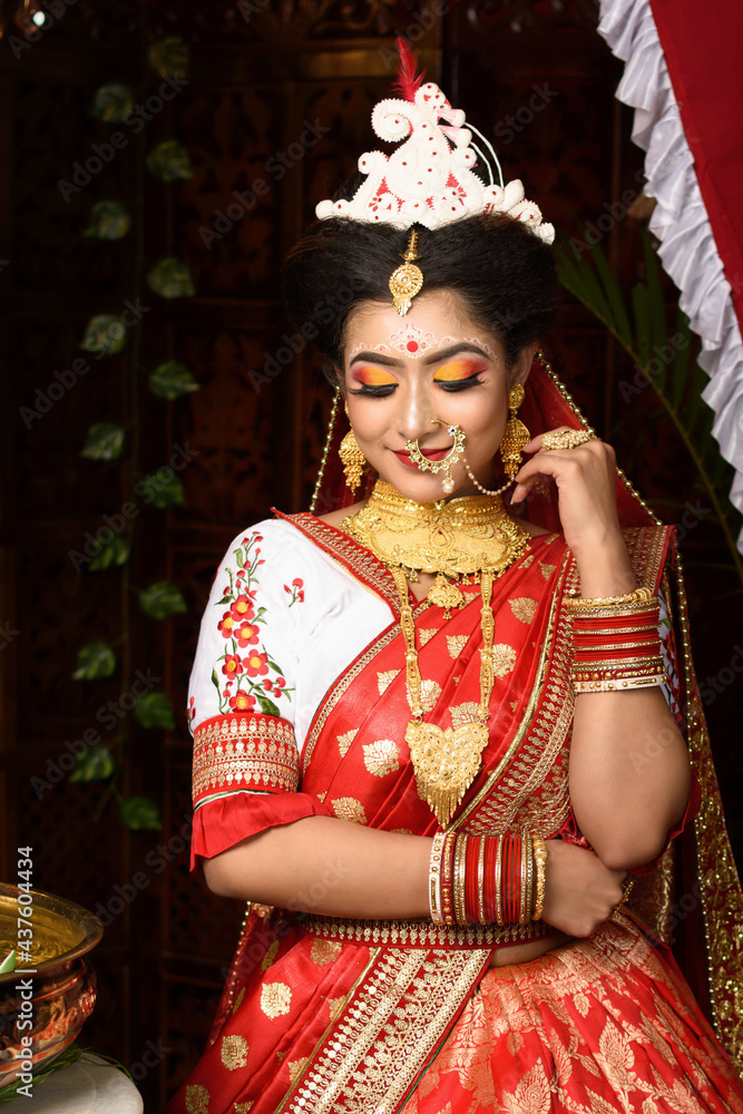 Stunning Indian bride dressed in traditional red Banarasi saree with ...