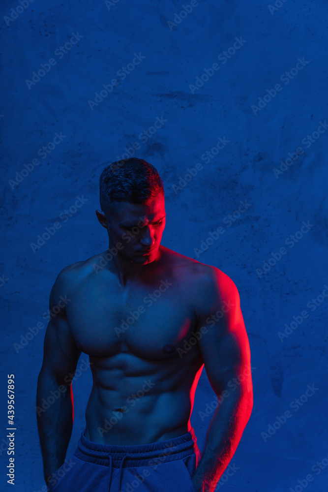 Bodybuilder is posing in the colorful neon light Stock Photo | Adobe Stock
