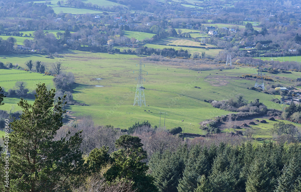 Beautiful bright aerial-like view of green fields, and high voltage ...