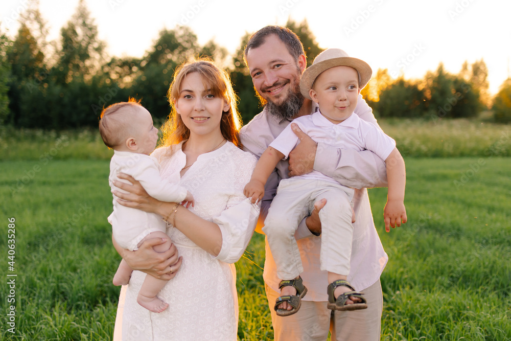 Traditional family in light clothes in the field nature. Walk at sunset ...