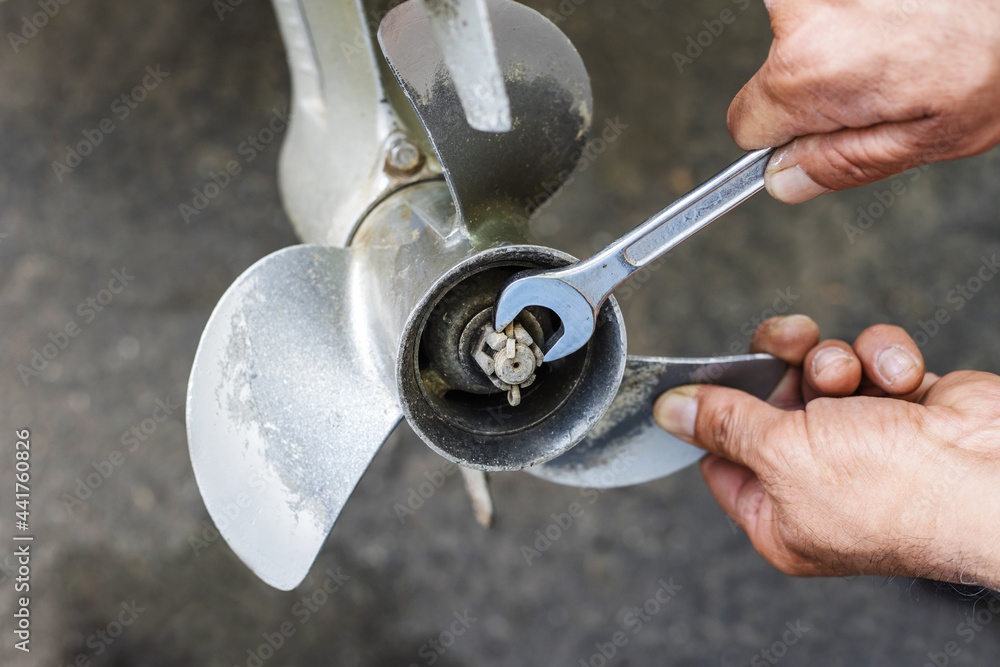 The process of replacing a boat propeller with a wrench. The technician ...