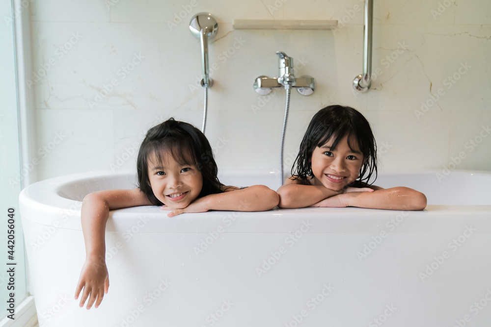 Foto de Stock two happy asian girl taking a bath together on a bathtub ...