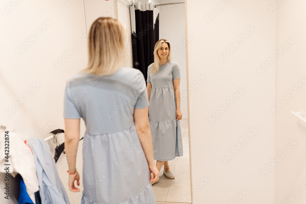Charming blonde really likes herself in mirror offitting room in ...