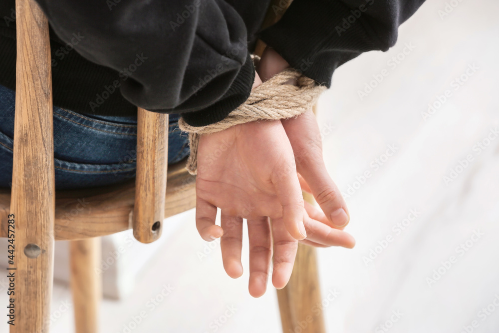 Female hostage with tied hands sitting on chair in room, closeup Stock ...