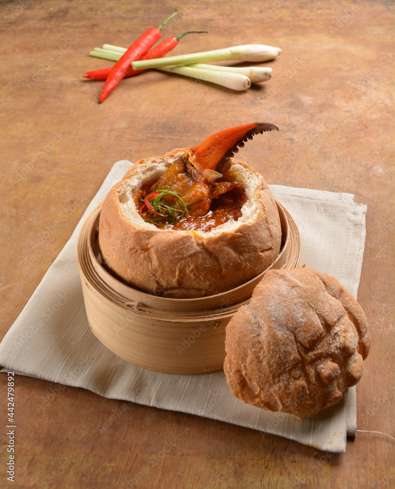 chef popular wok fried spicy chilli crab meat in round big baked bread ...