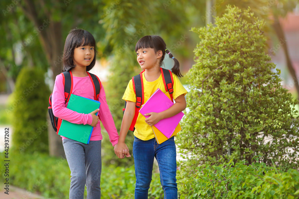 Back to school after covid-19 epidemic.Two cute little girl walking and ...