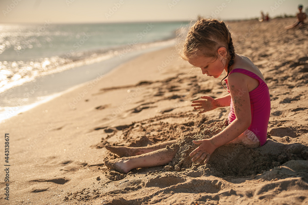 Cute little girl playing in the sand Stock Photo | Adobe Stock