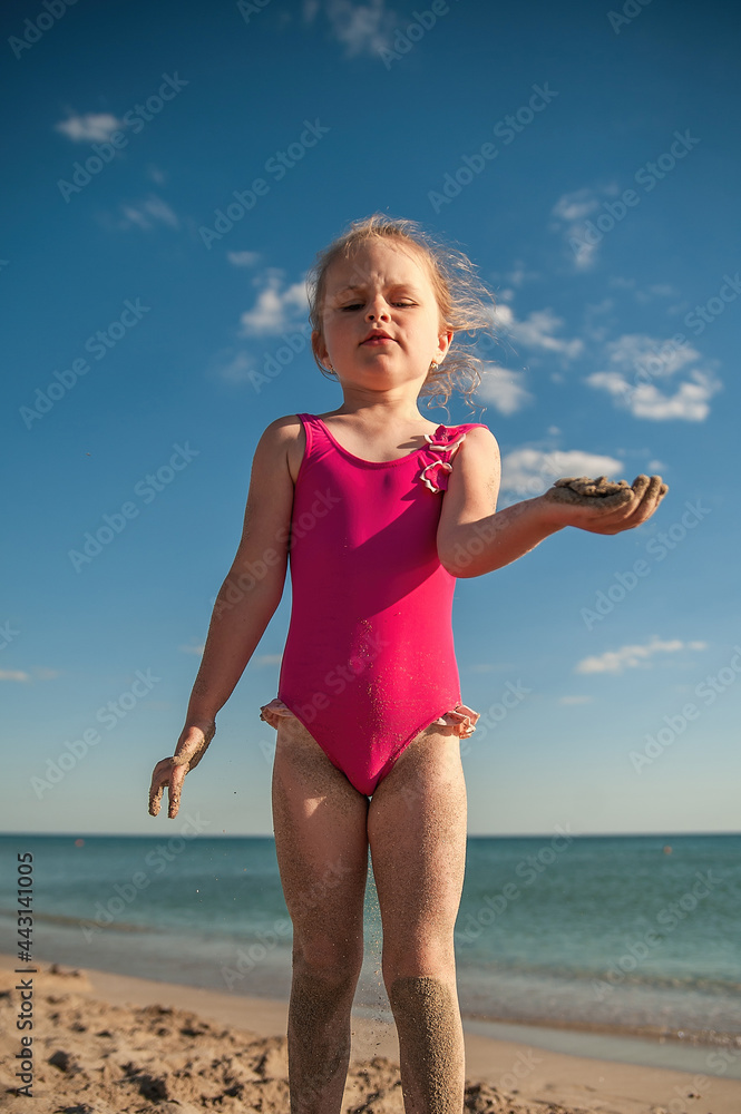 Cute little girl playing in the sand on the sea beach Stock Photo ...