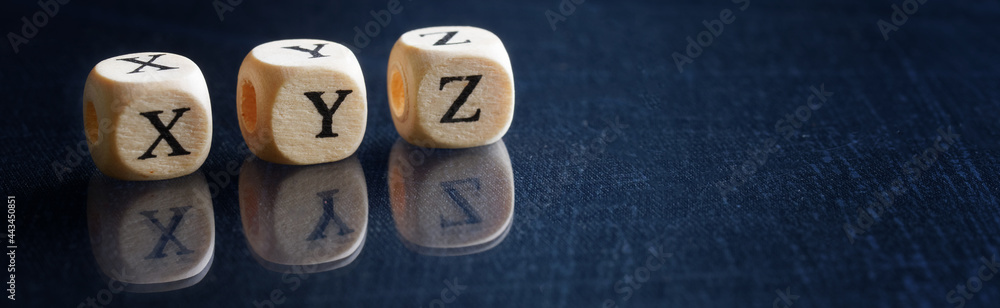 Three last letters of the English alphabet x, y, z on wooden cubes ...