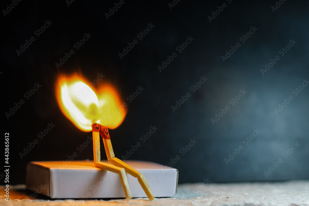 Two matches burning sitting together on the matchbox in the dark copy ...