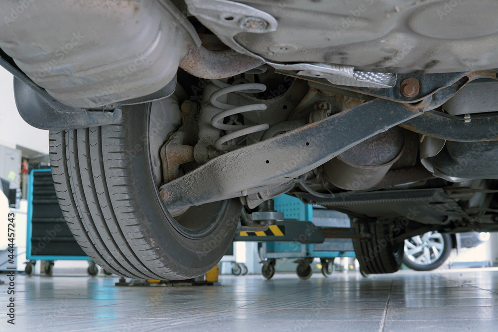 Modern car in a car service on a lift. Bottom view of the rear ...