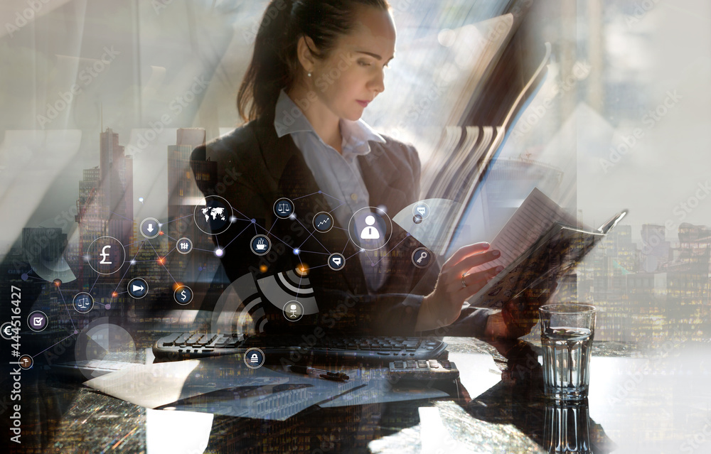 Attractive business woman working by her desk in office against sun ...