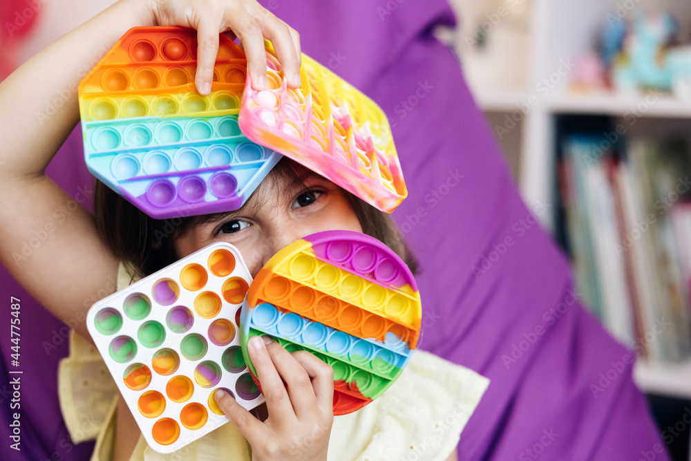 Stock-Foto „Portrait little girl with a modern popit toy. Trendy ...