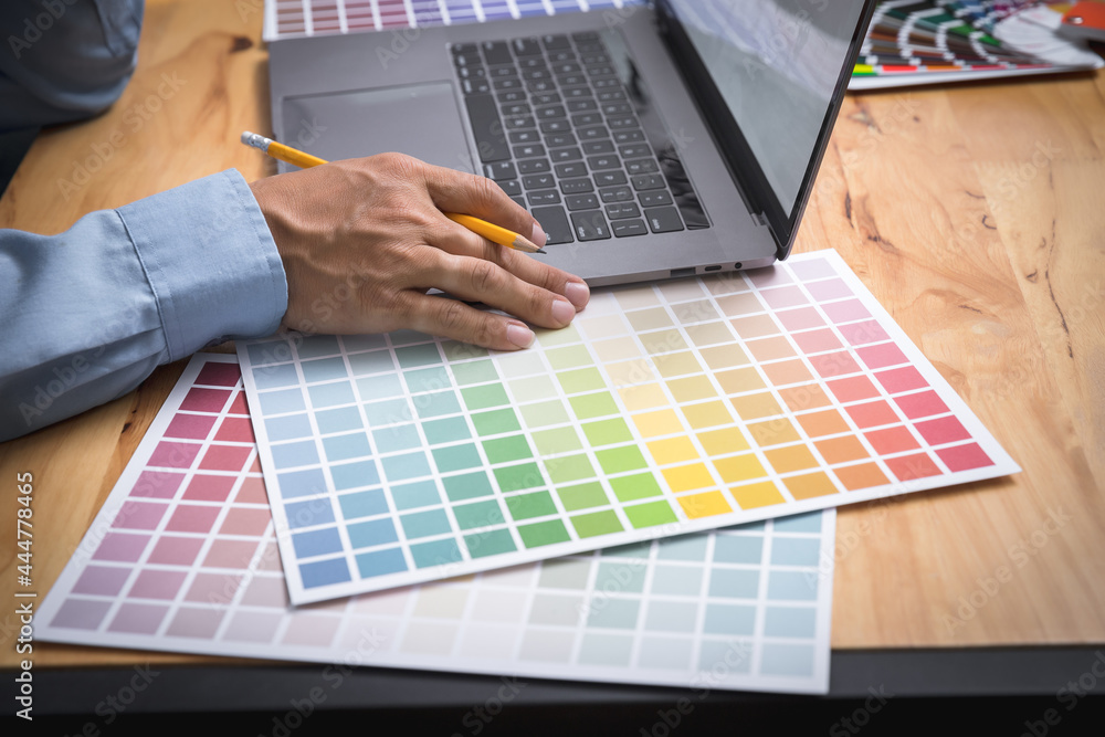 Photographer Graphist designer working on a laptop with colors chart ...