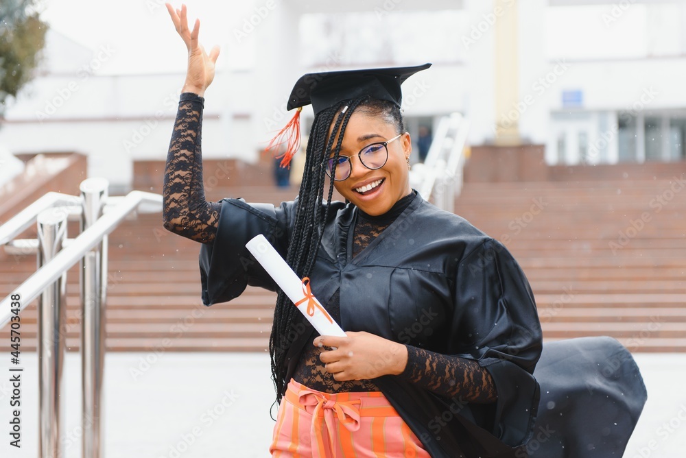 pretty african college student in graduation cap and gown in front of ...
