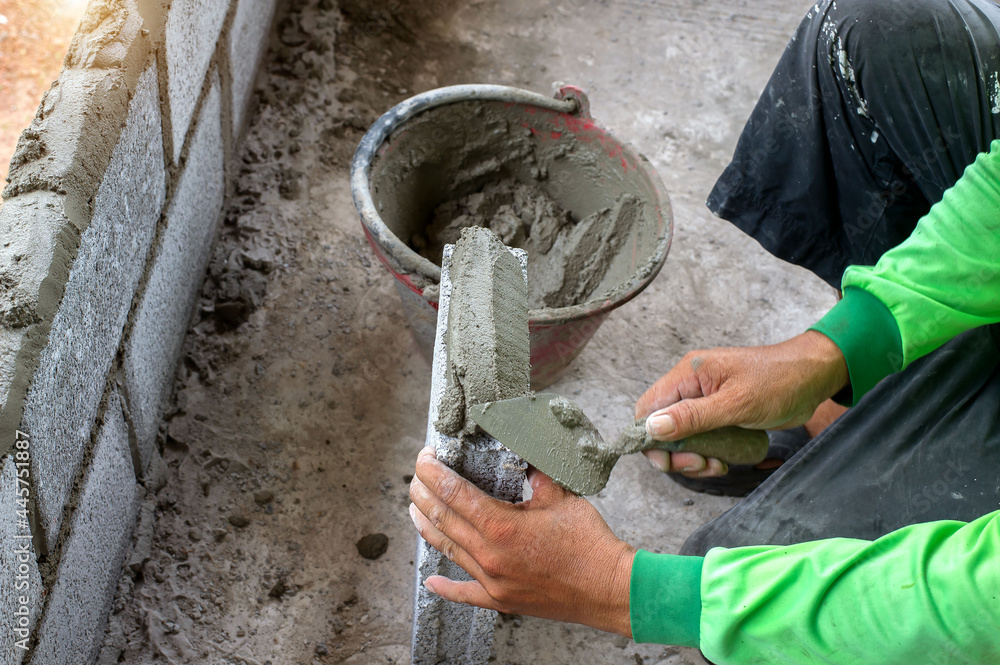 masonry worker make concrete wall by cement block and plaster at ...