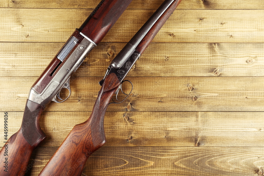 hunting rifles on a wooden background flat lay with empty space close ...