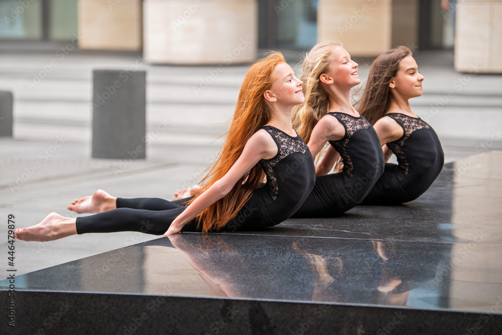 group of three teenage girls dancers gymnasts in black tight suits with ...