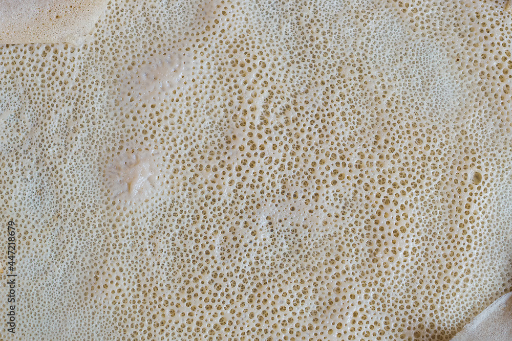 Close up of Injera, a fermented flatbread made with teff flour. It is ...