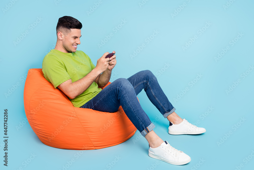 Full body photo of charming young happy man sit chair hold hand phone ...