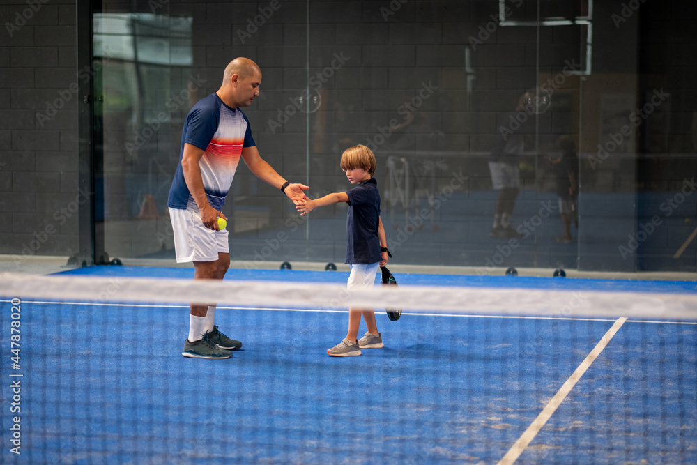 Monitor teaching padel class to child, his student - Trainer teaches ...