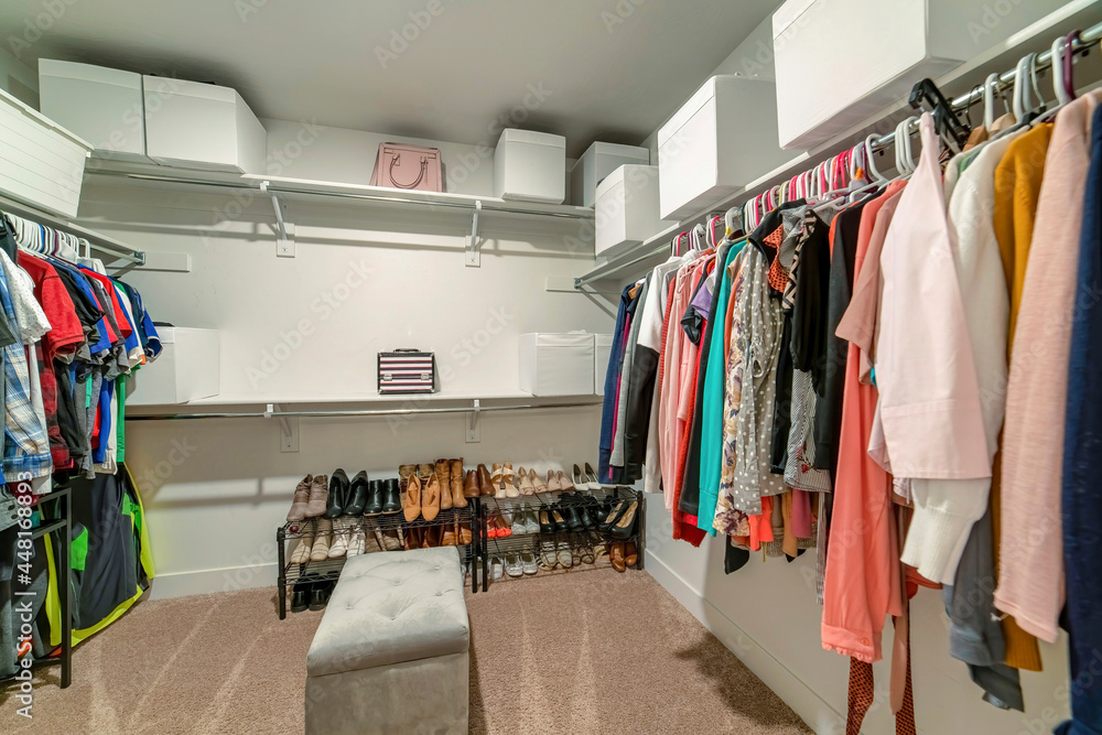 Interior of a walk in closet with ottoman and white storage boxes Stock ...