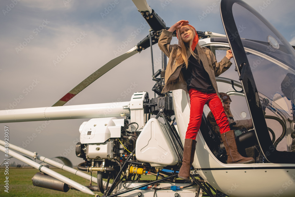 Full length portrait of tween girl looking at sky from open cockpit of ...