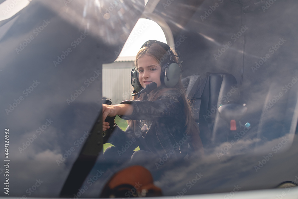 View through glass of tween girl in helicopter cockpit reaching out to ...