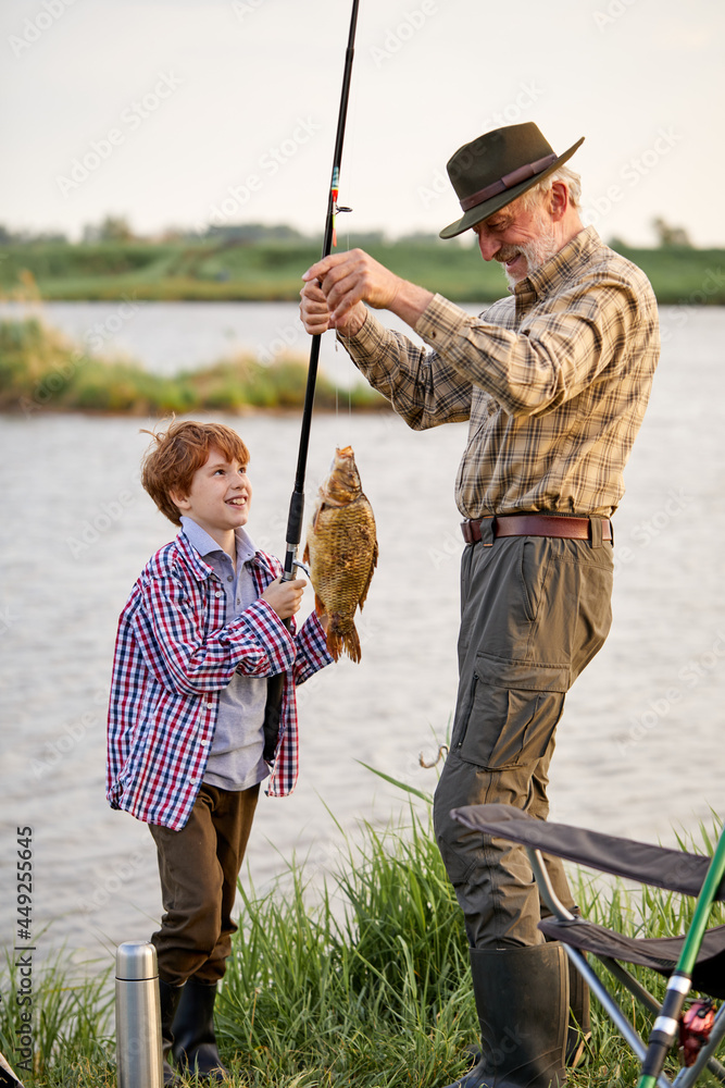 Catch of the day. Happy grandfather and child boy fishing while on the ...