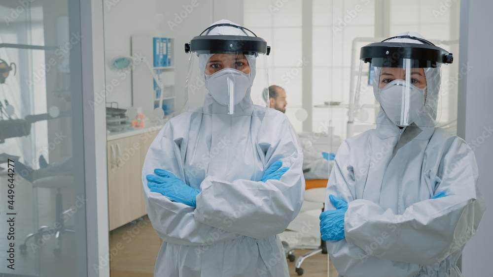 Professional team of dentists in ppe suits standing in dental cabinet ...
