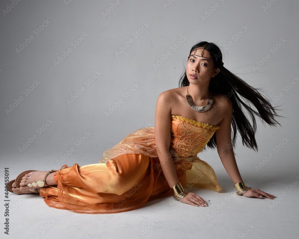 Full length portrait of pretty young asian woman wearing golden Arabian ...