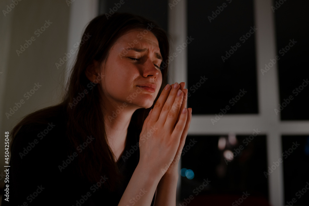 Young woman praying and crying at night Stock Photo | Adobe Stock