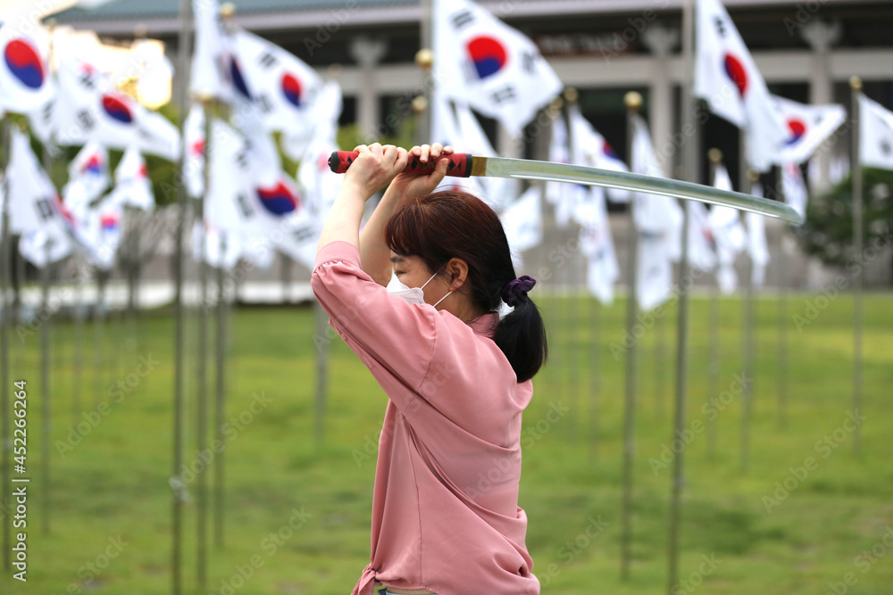 Korean woman practicing kendo in a hi-dong kendo pose with a sword ...