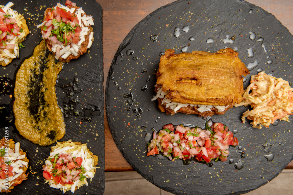 Top view image of Venezuelan patacones and arepas with coleslaw, pico ...