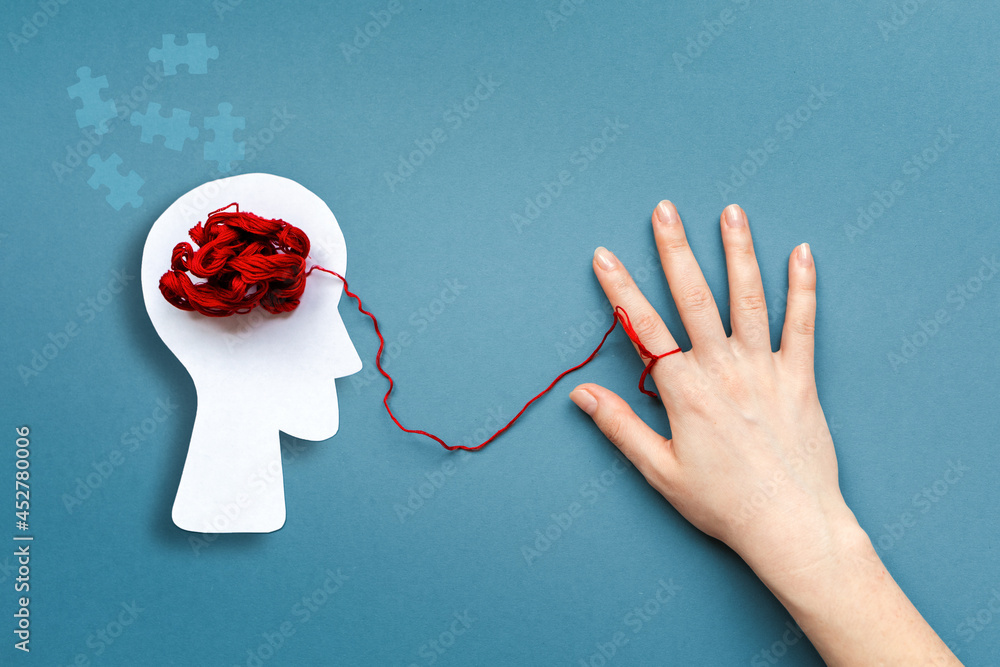 Silhouette of a paper human head with tangled red threads instead of ...