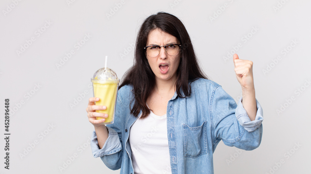 pretty woman shouting aggressively with an angry expression and holding ...