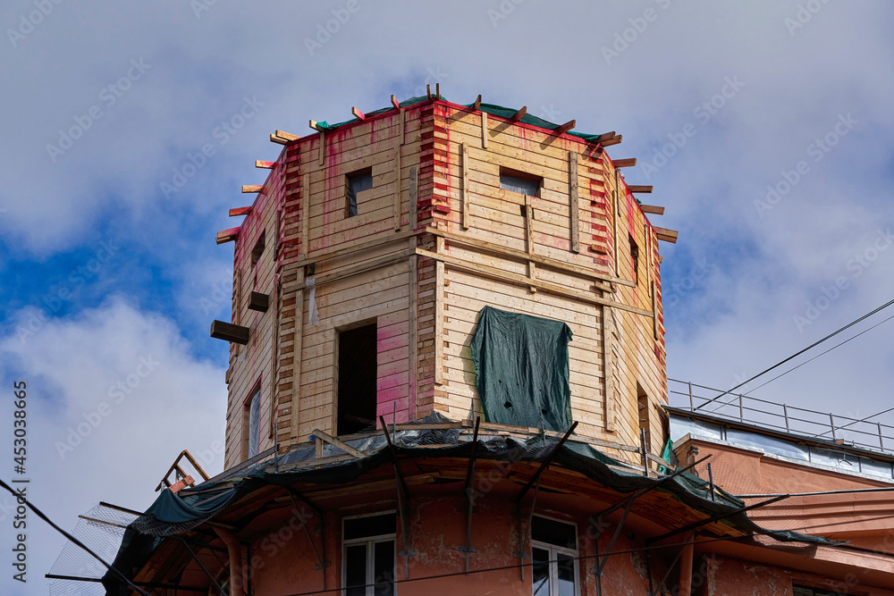 Wooden superstructure in the form of a tower over a brick building ...