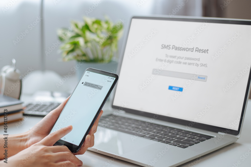 Foto de Stock Woman hand holding phone showing security code and enters one-time password for ...