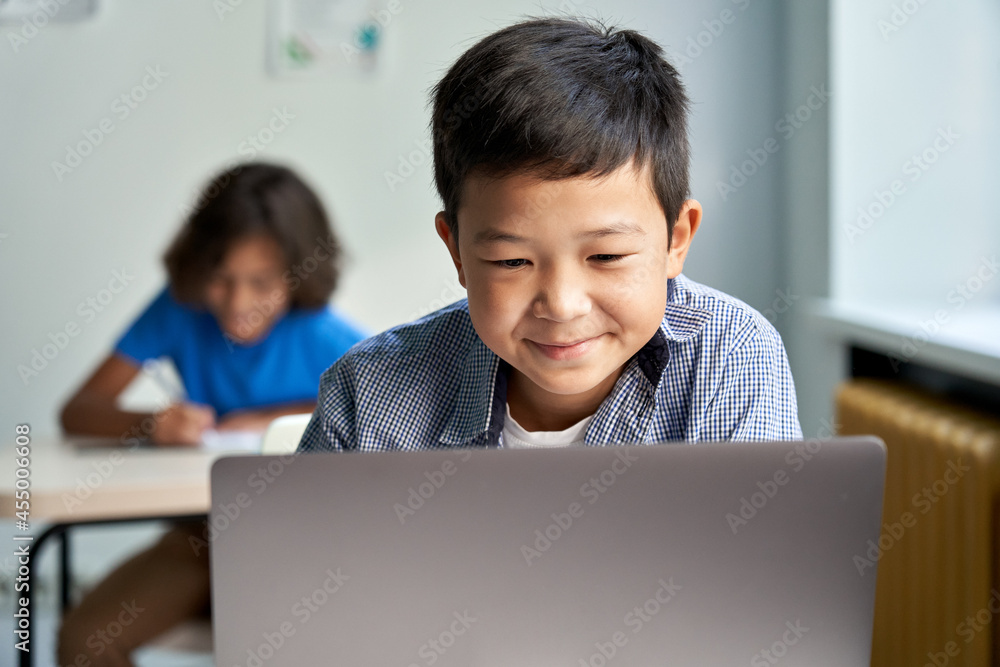 Foto Happy smiling Asian school boy using laptop computer at class in ...